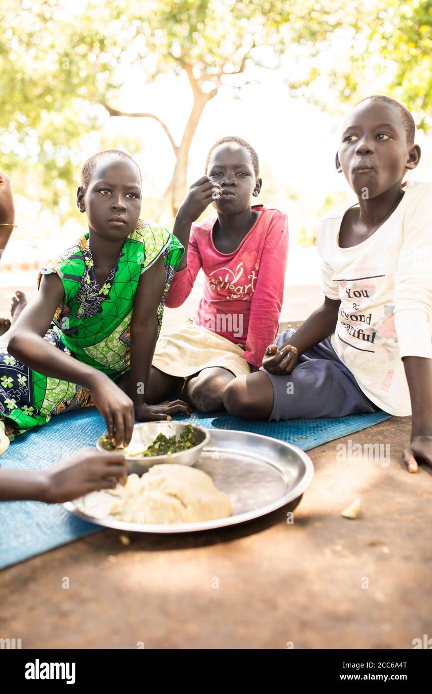 Children eat okra soup with ugali (posho, nshima), a dough-like starch ...