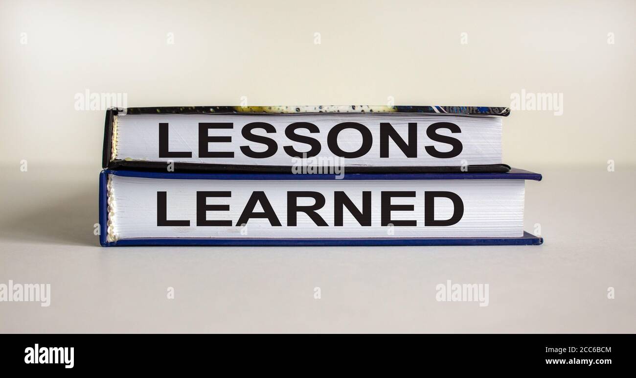 Books with text 'lessons learned' on beautiful white table. White ...