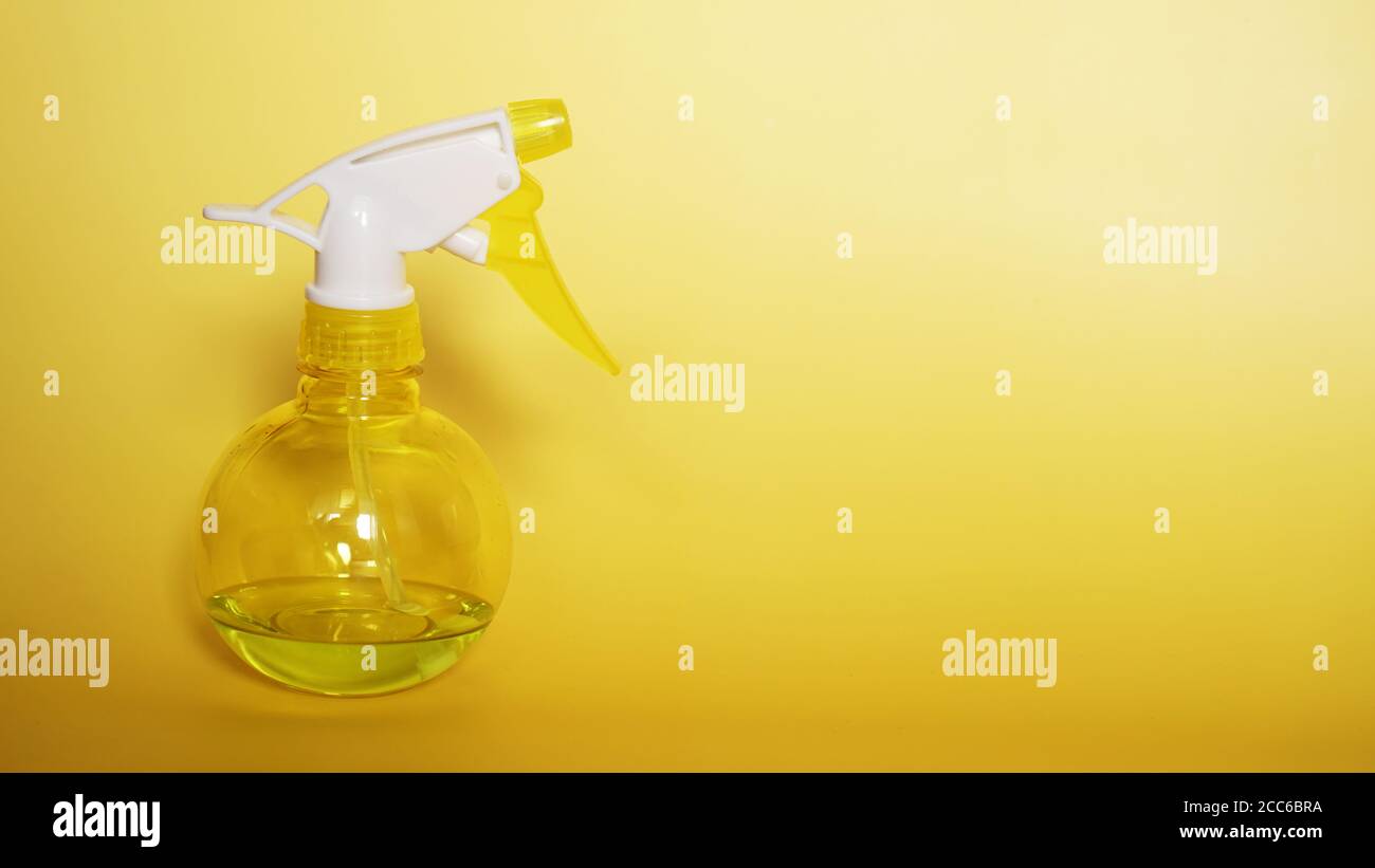Spray bottle on yellow background. Portable pressure water sprayer pump ...