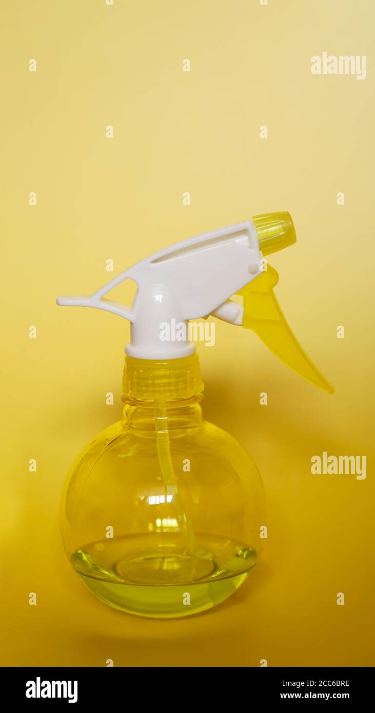 Spray bottle on yellow background. Portable pressure water sprayer pump ...