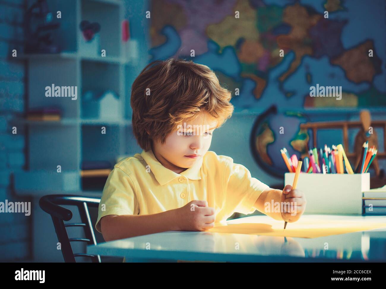 Smiling little boy drawing in the room Stock Photo - Alamy