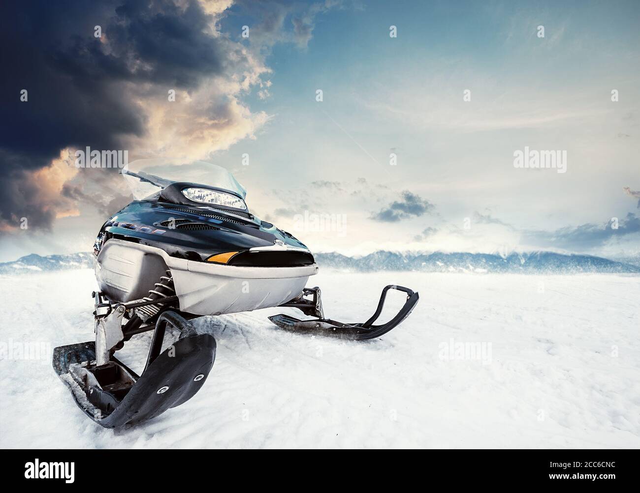 Snowmachine on the mountain lake frozen surface with thunderstorm ...
