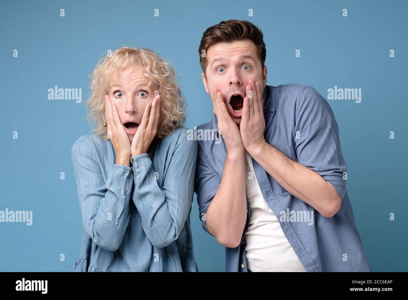 Shocked man and woman screaming and touching face Stock Photo - Alamy