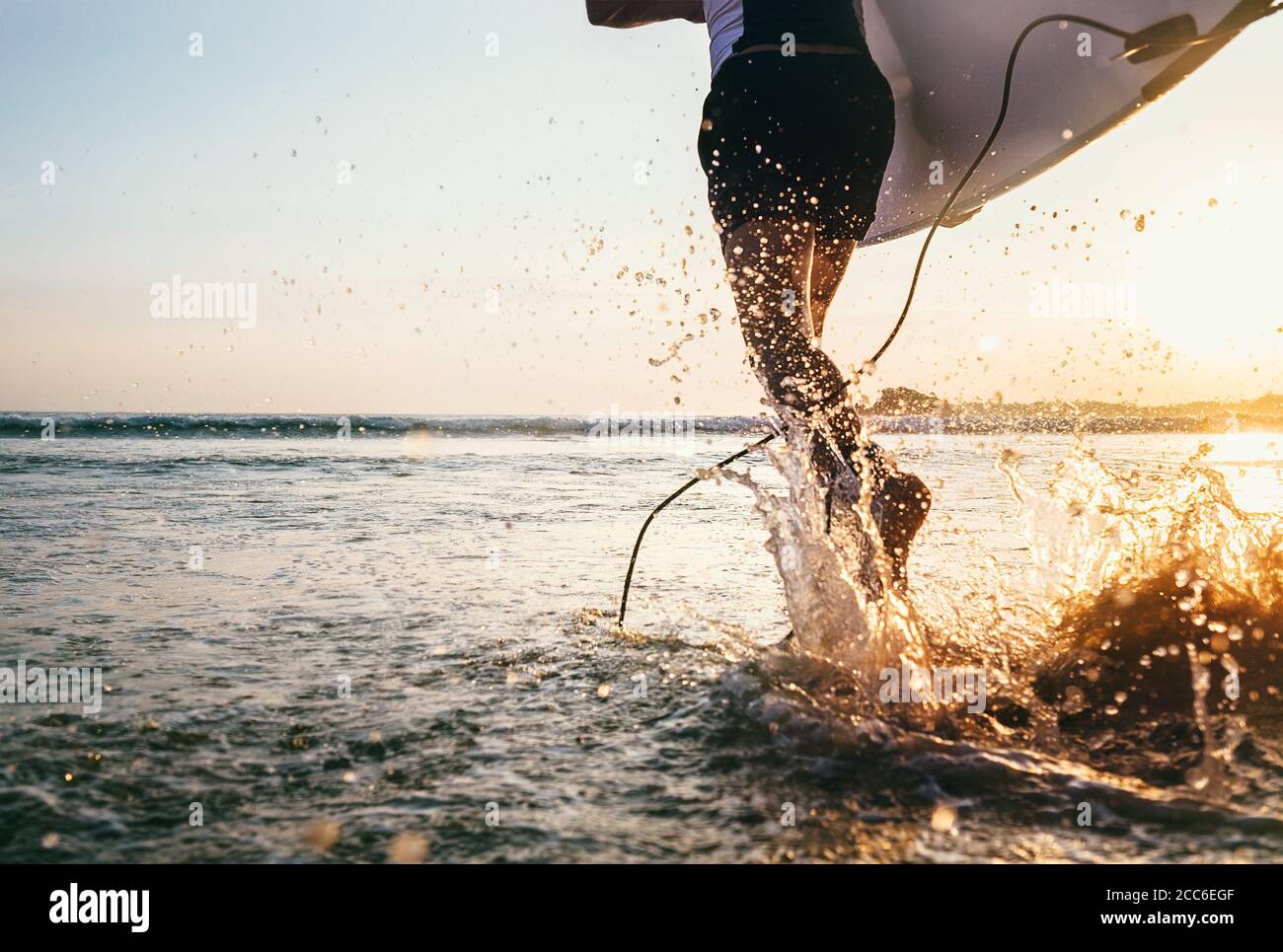 Closeup image water splashes from surfer's legs run in ocean with ...