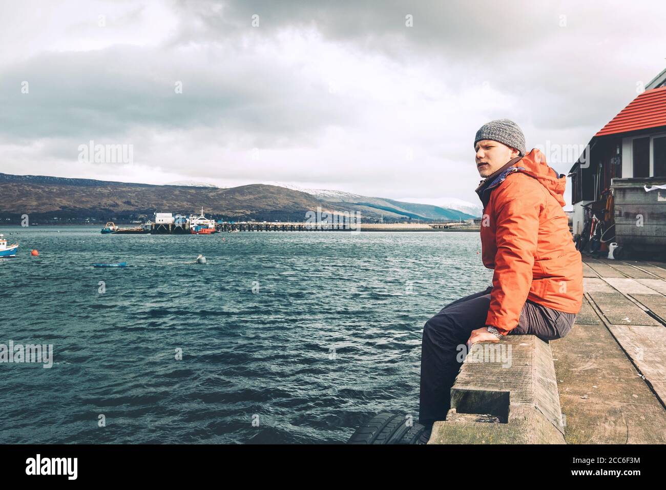 Young man sits on pier hi-res stock photography and images - Alamy