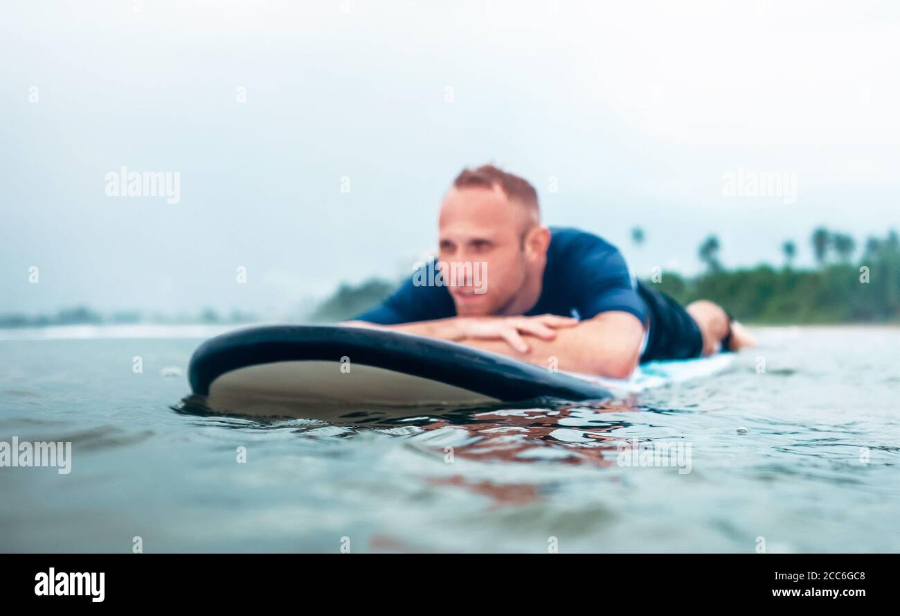 Resting surfer man on the board Stock Photo - Alamy