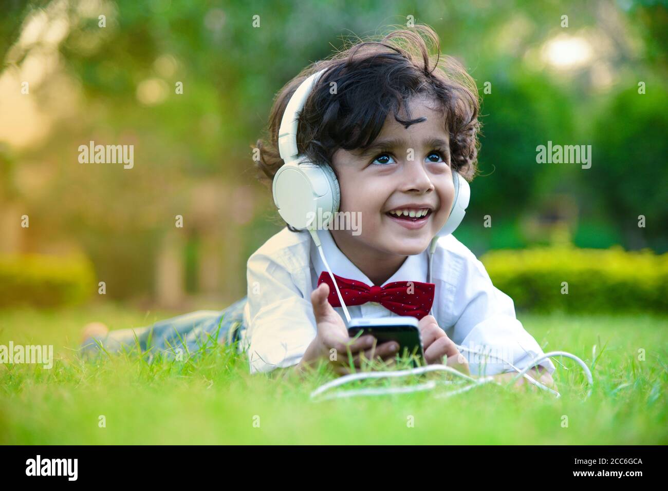 beautiful fashionable boy listening music in headphone from smartphone ...