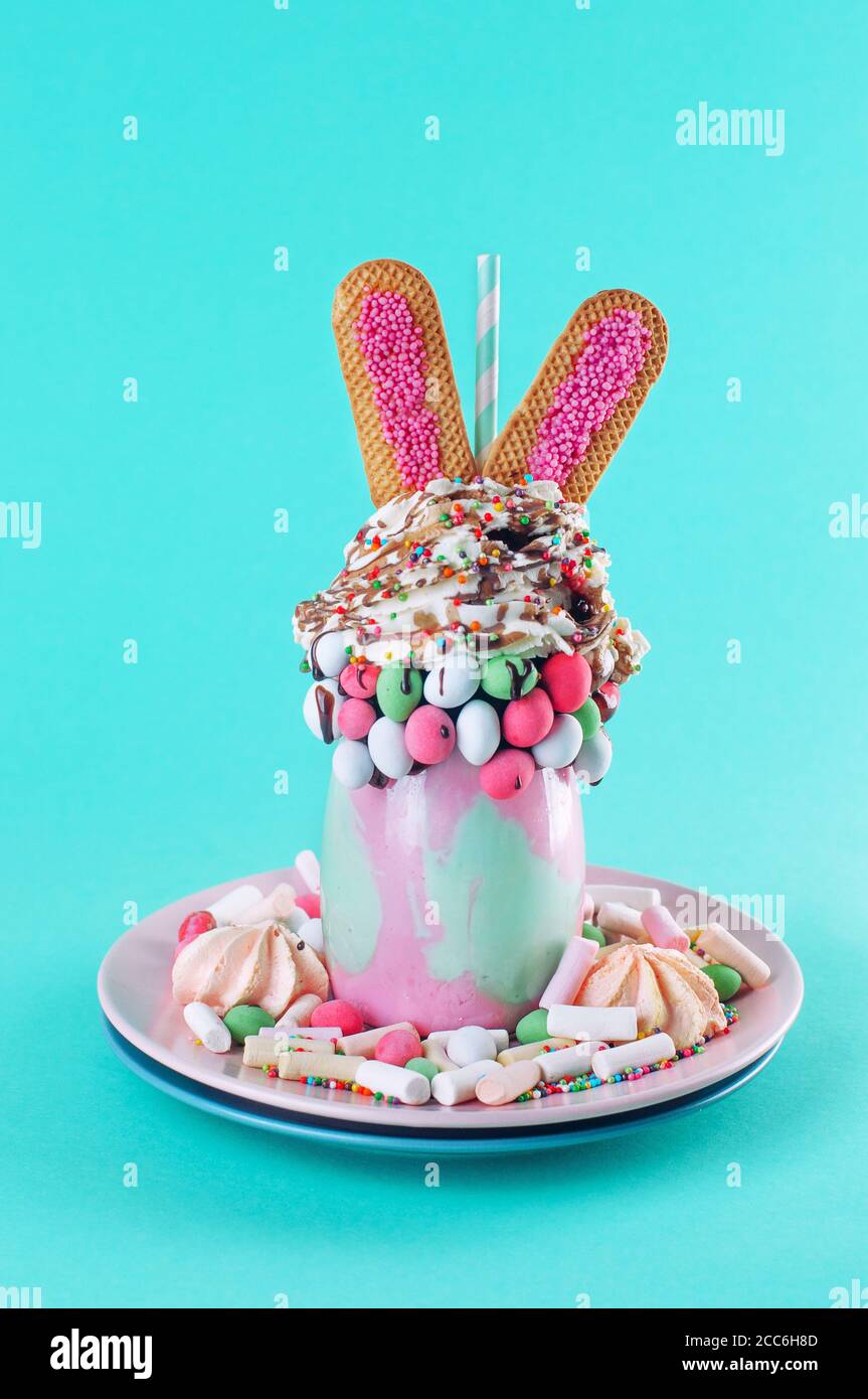 Easter freak shake with bunny ears cookies on light blue background ...