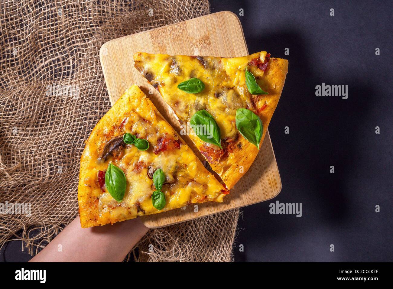 Two slice pizza basil leaves on black background, top view. flat lay ...