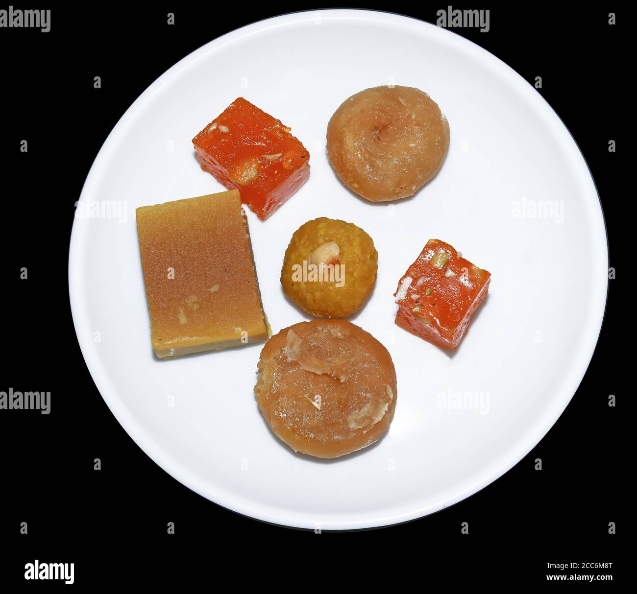 Indian sweets served in white plate. Halwa, badusha, ghee mysore pak ...