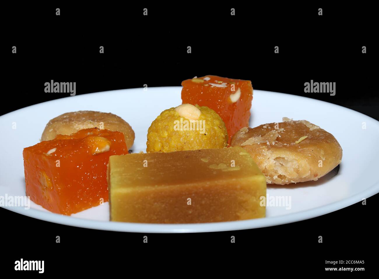 Indian sweets served in white plate. Halwa, badusha, ghee mysore pak ...