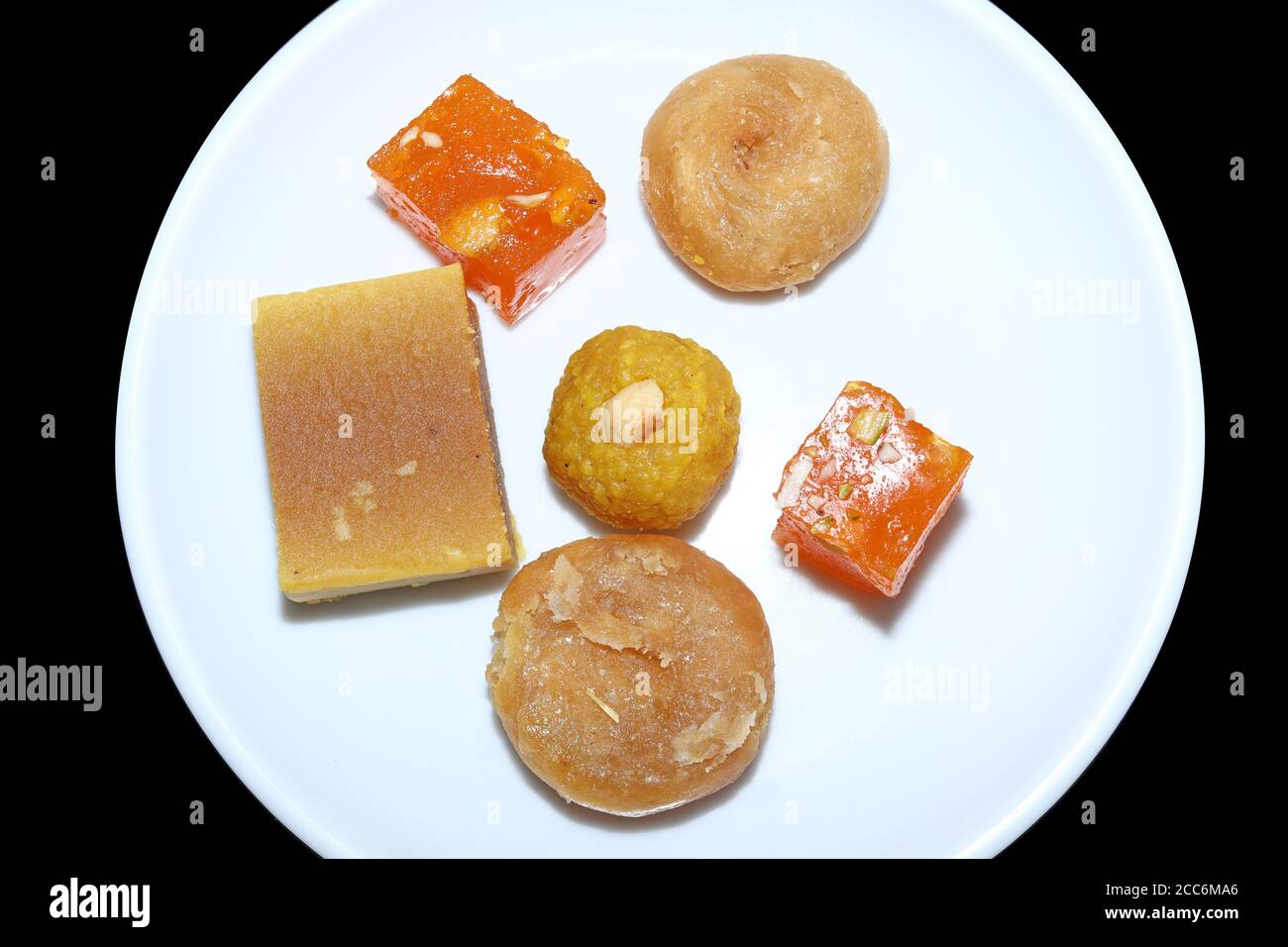 Indian sweets served in white plate. Halwa, badusha, ghee mysore pak ...