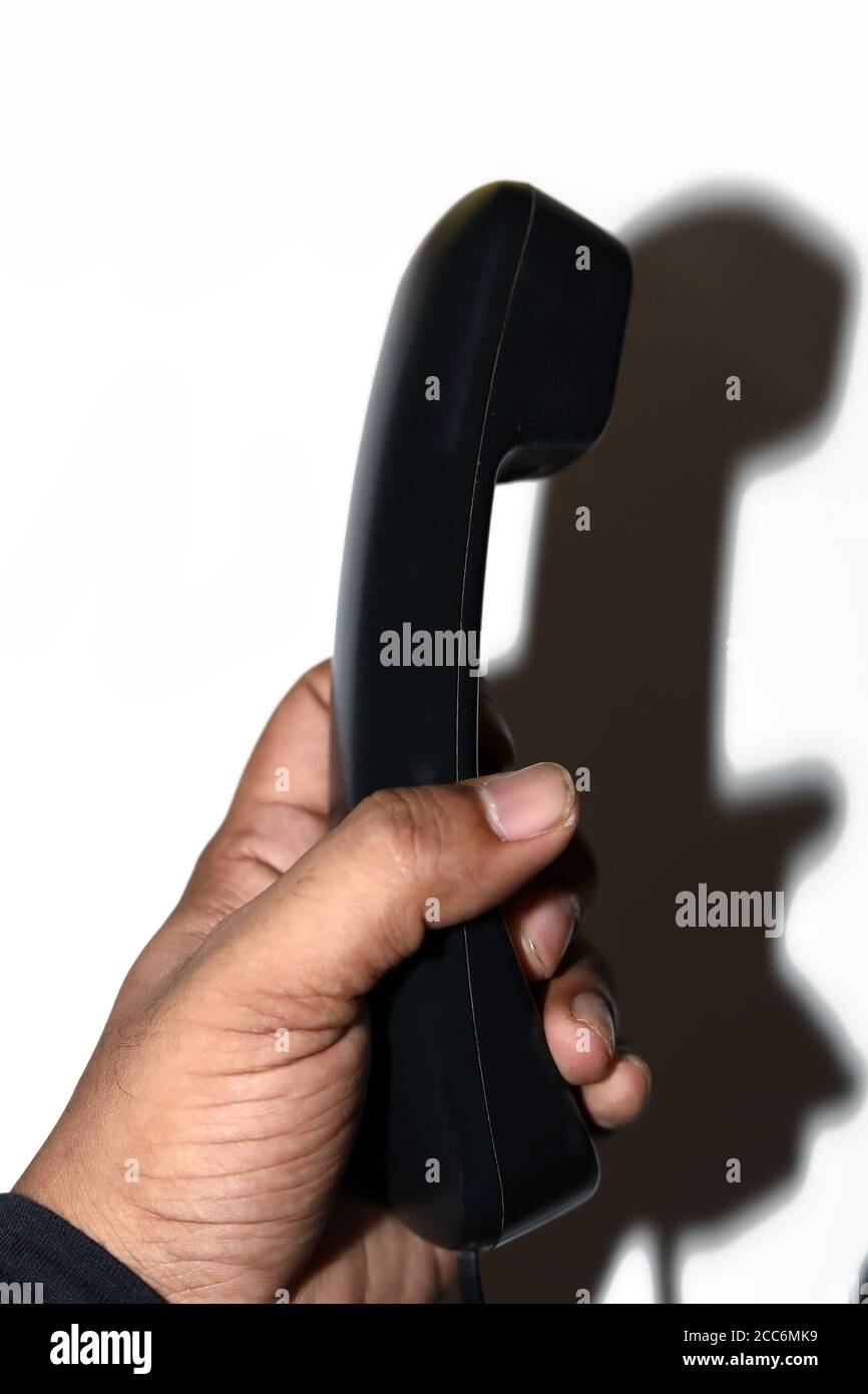 Male hand holding phone receiver on white backgrounds Stock Photo - Alamy