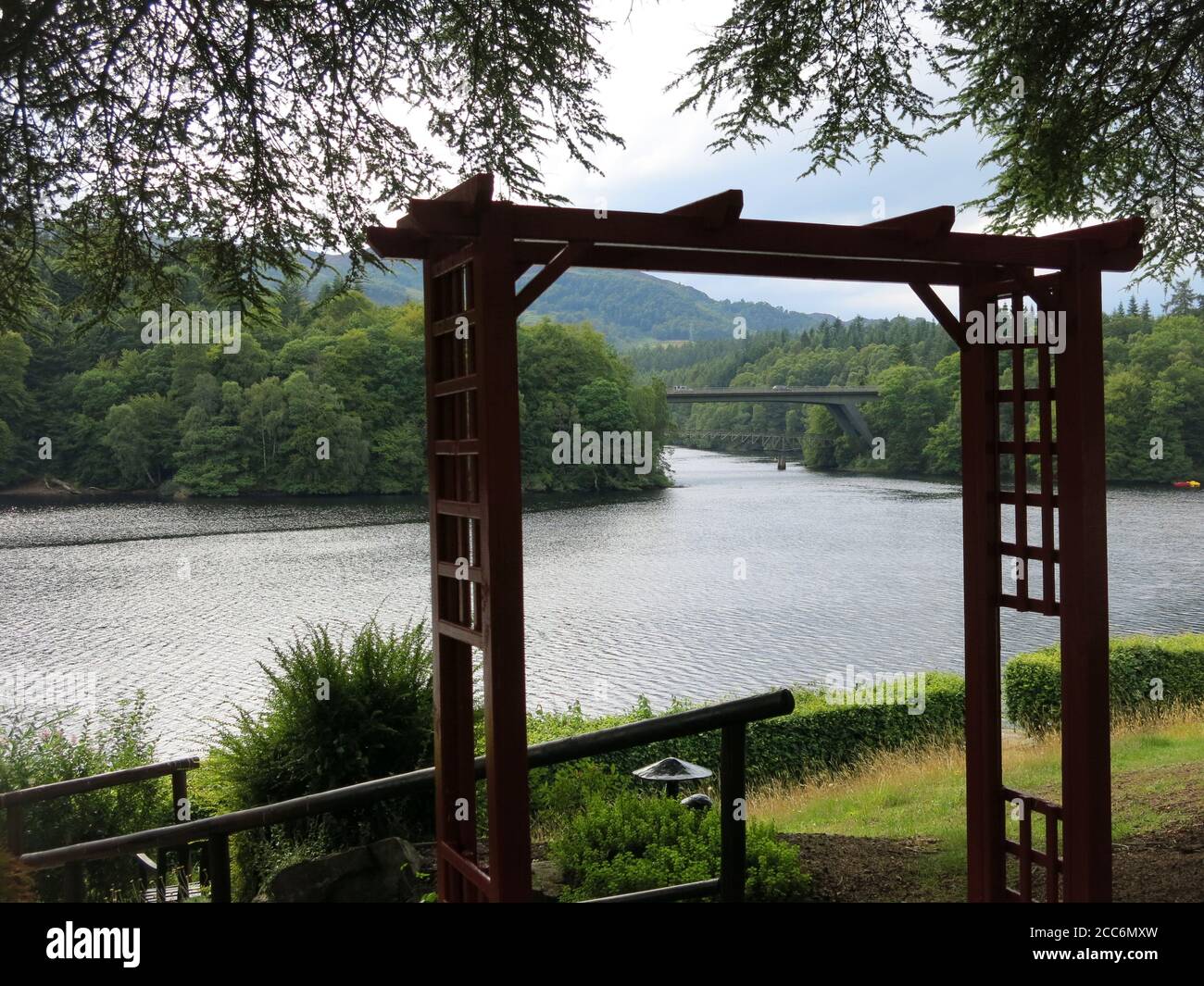 Framed by a latticed pergola, a view overlooking Loch Faskally in ...