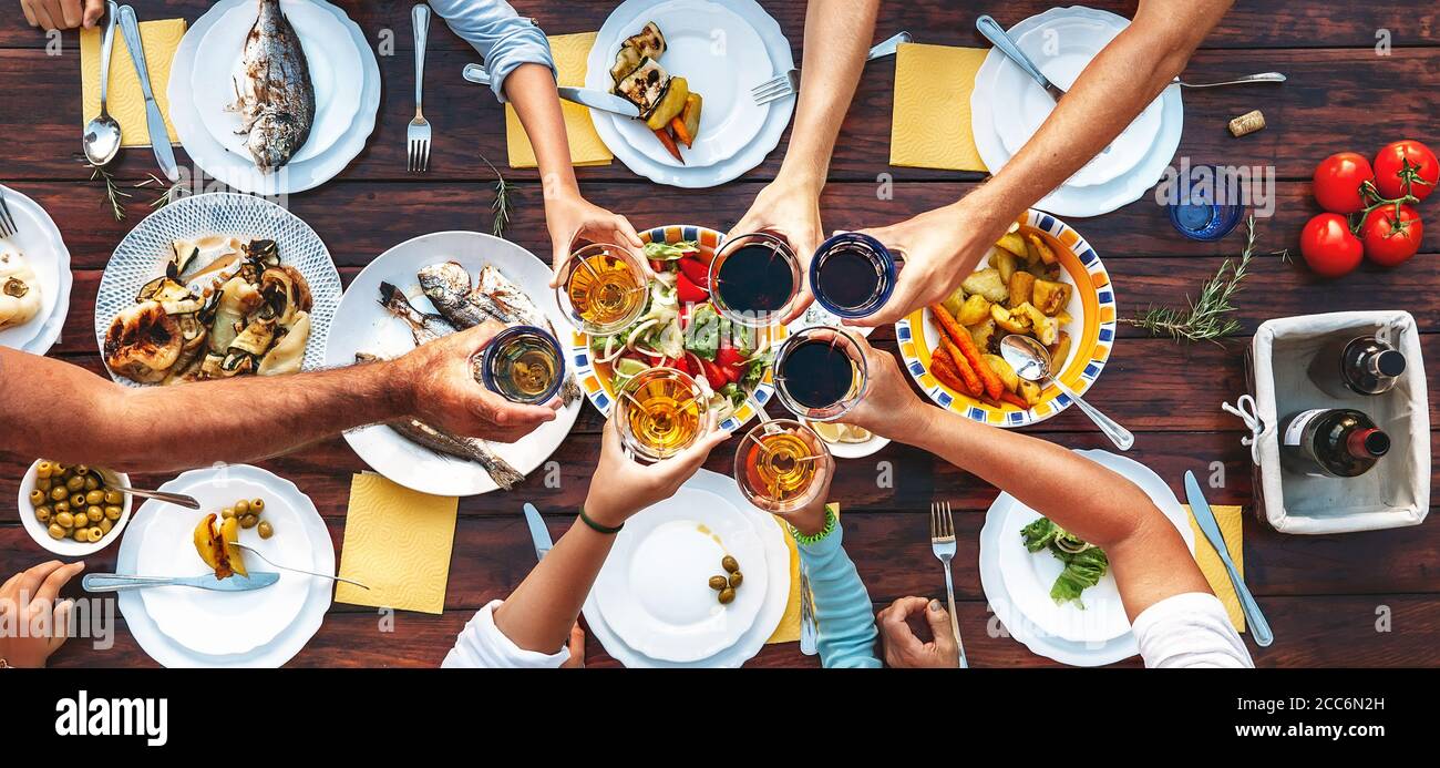 Big family dinner. Vertical top view on served table and hands with ...