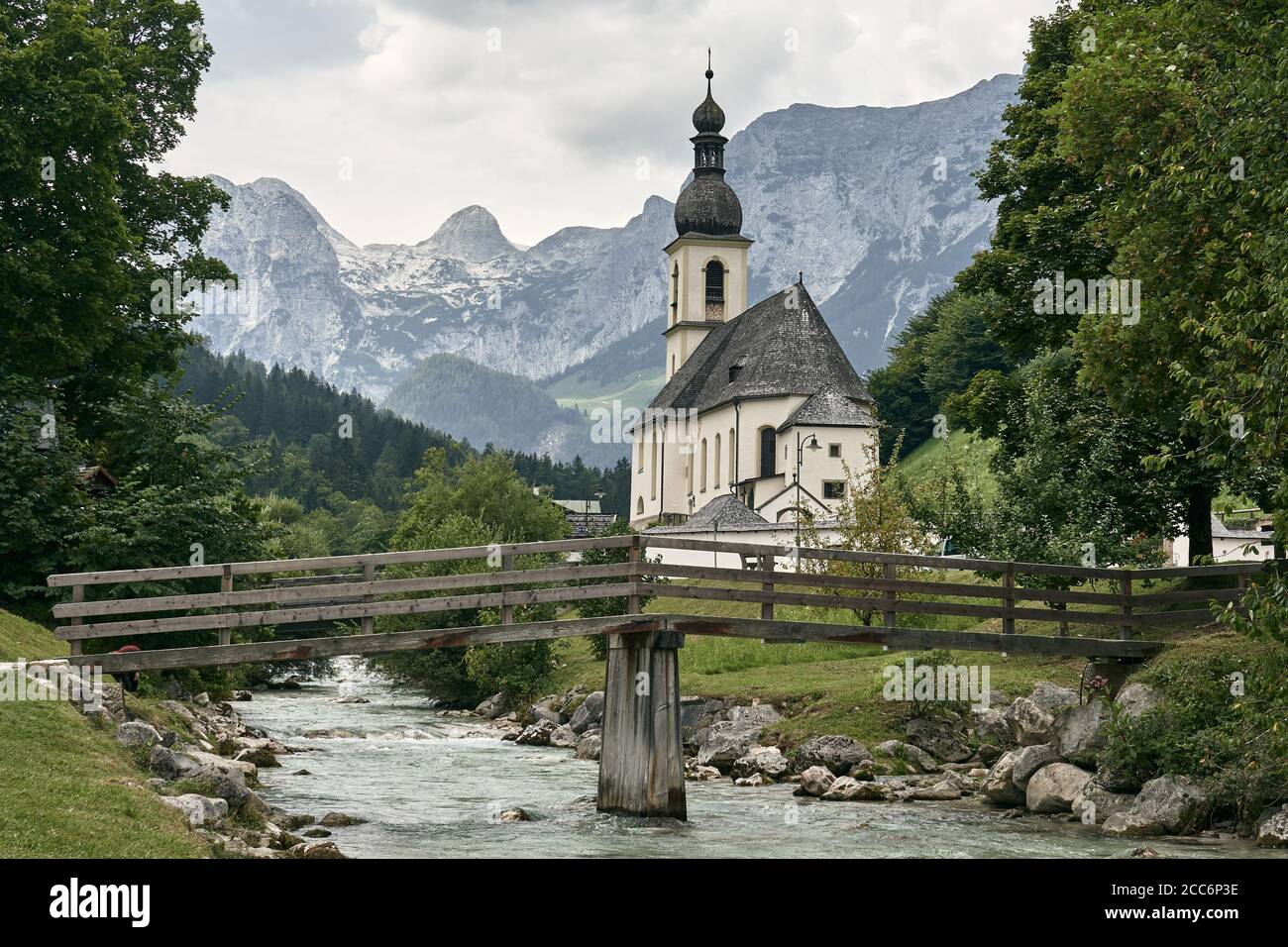 St. Sebastian church with mountain stream and bridge in Ramsau ...