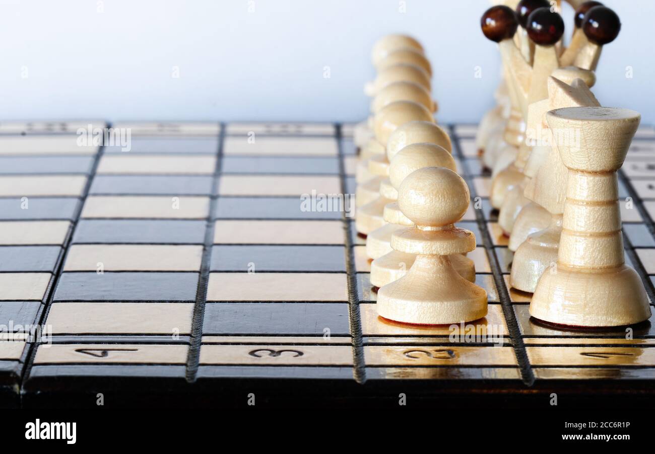White chess pieces arranged on chess board before start of gameplay as ...
