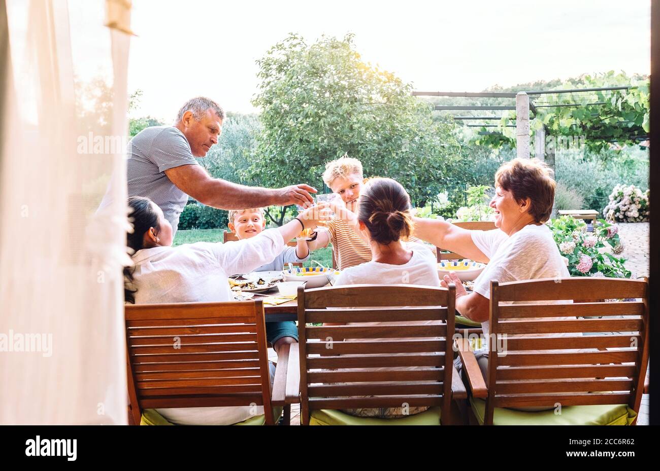 Three generations one family have dinner in summer garden Stock Photo ...