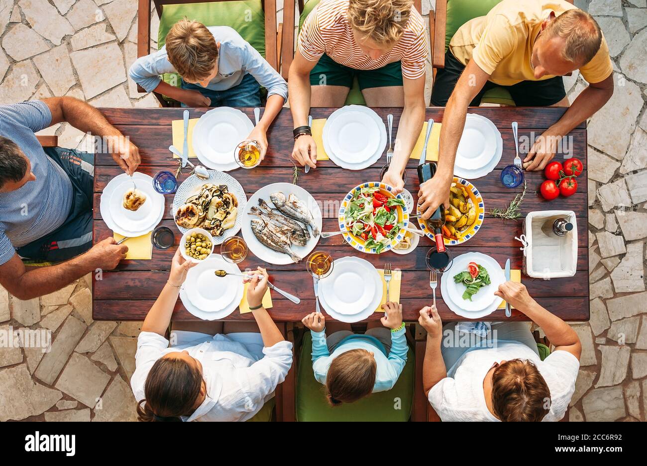 The big family have dinner with a freshly cooked meal on the open ...