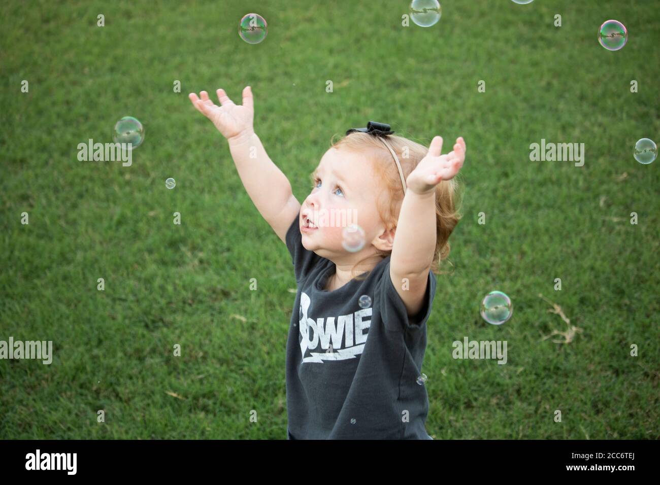 Baby girl chasing bubbles Stock Photo - Alamy