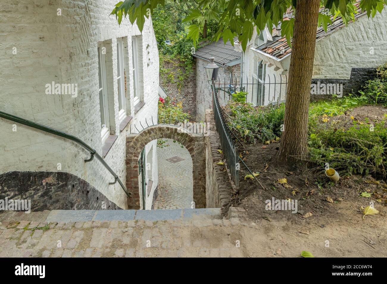 Perspective of an alley with a staircase down with a metal railing ...