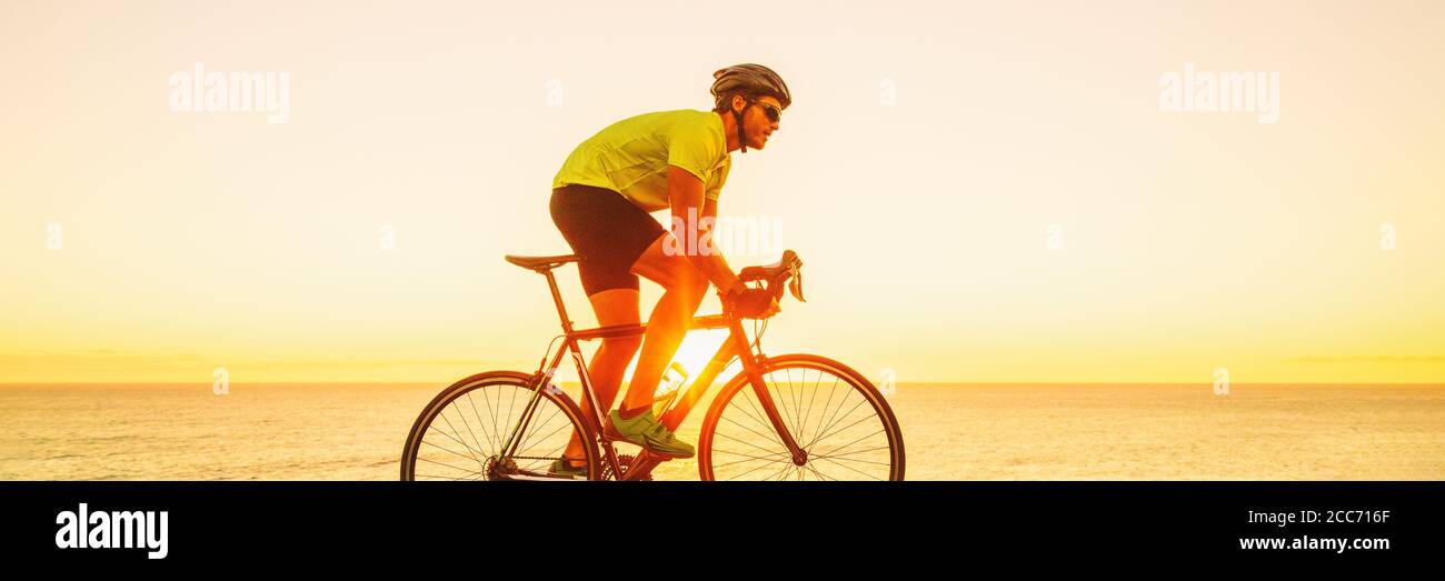 Triahtlon athlete man biking on road racing bike ride outdoors at ...