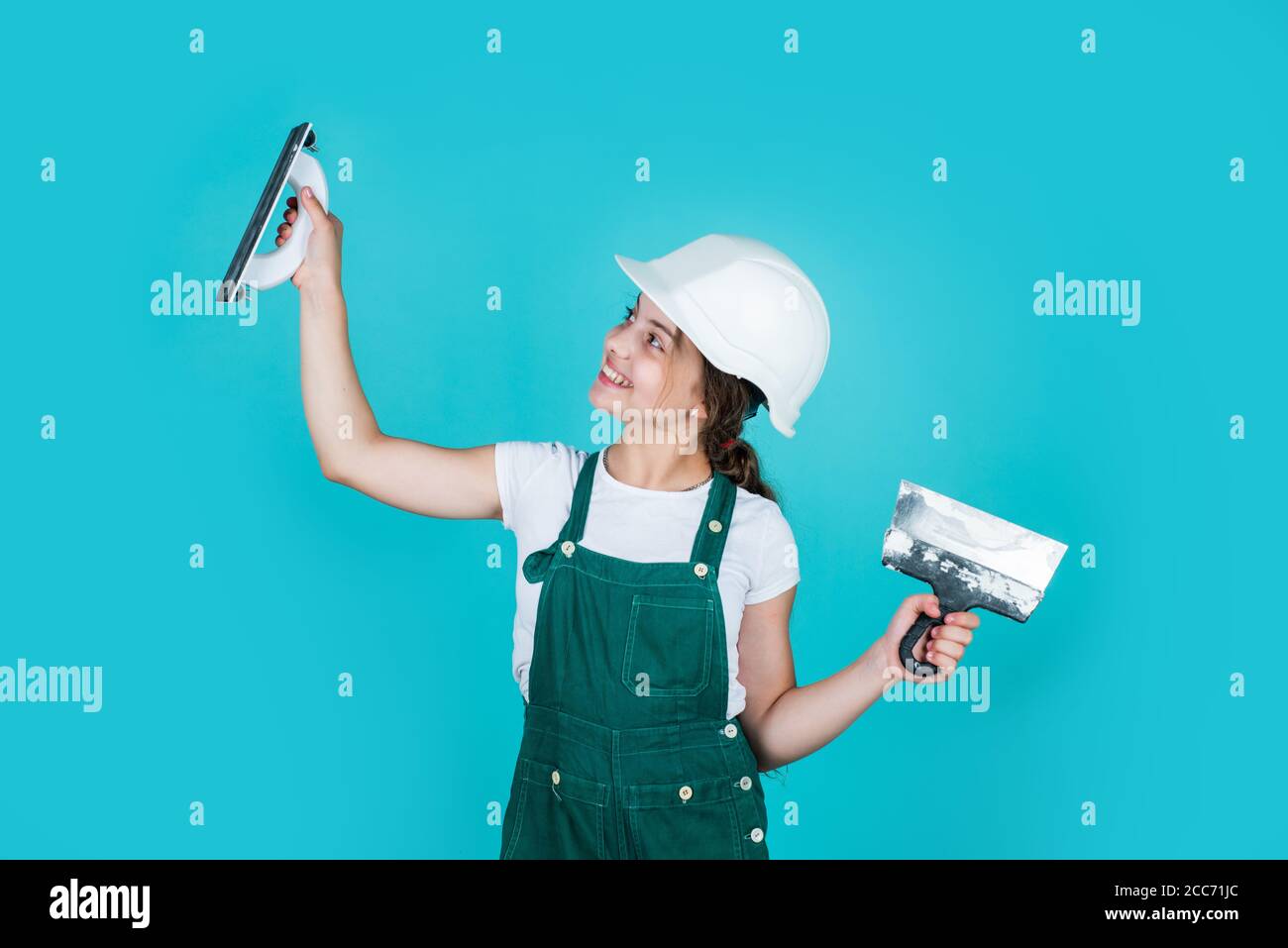 small builder using putty knife. kid with helmet holding spatula. kid ...