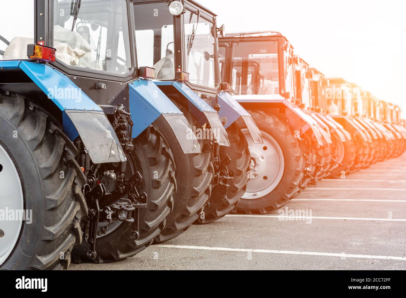 Many different tractors standing in row at agricultural fair for sale ...