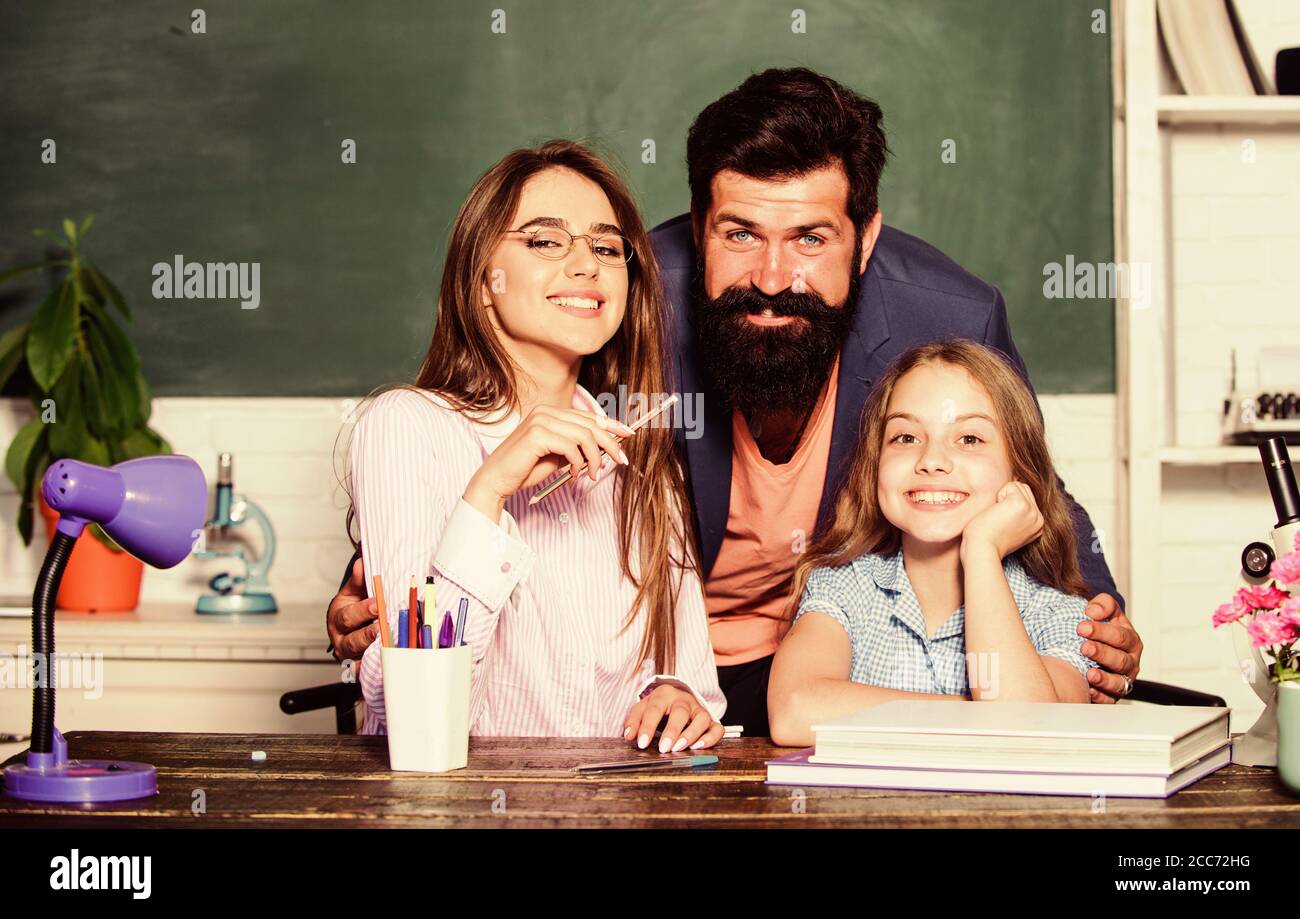 Extra classes. Gifted child. Little girl studying with team of tutors ...