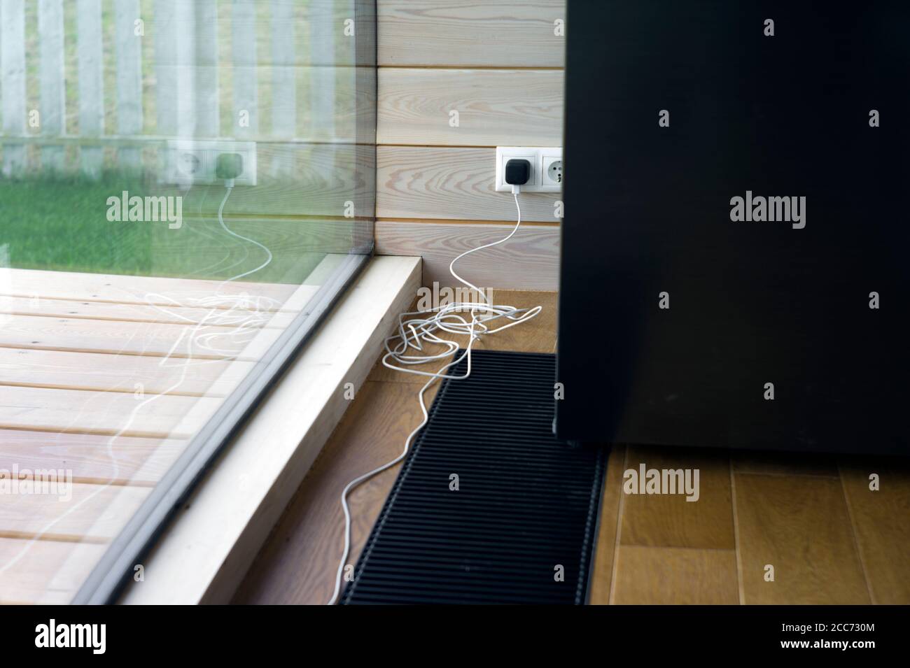 Charger and tangled cable on the floor of a modern room Stock Photo - Alamy