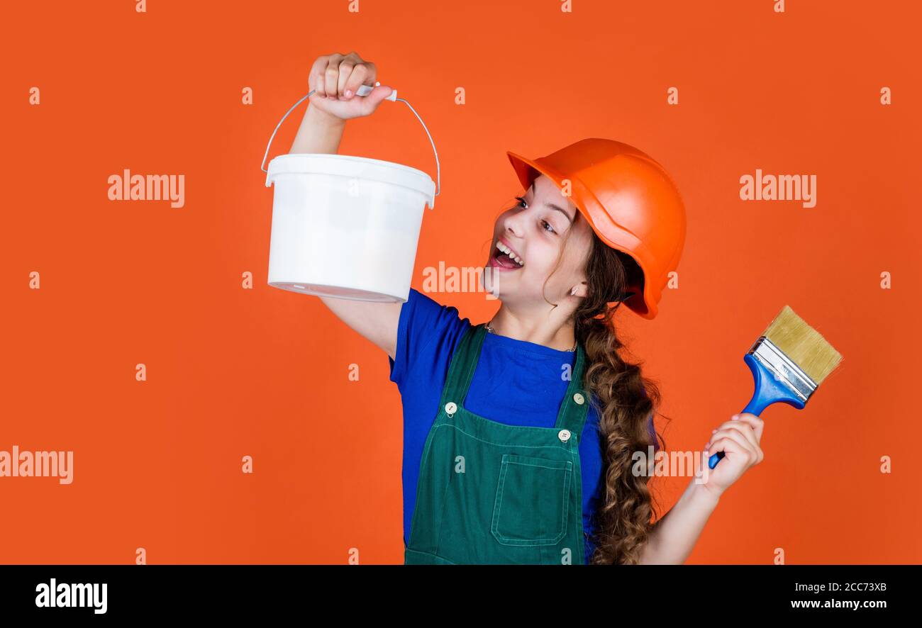 ready to paint. girl in protective helmet painting the wall. childhood ...