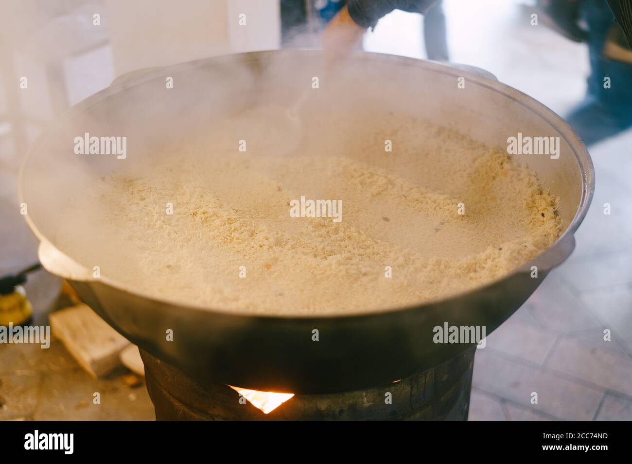 Raw rice was poured into a huge cauldron with pilaf Stock Photo - Alamy