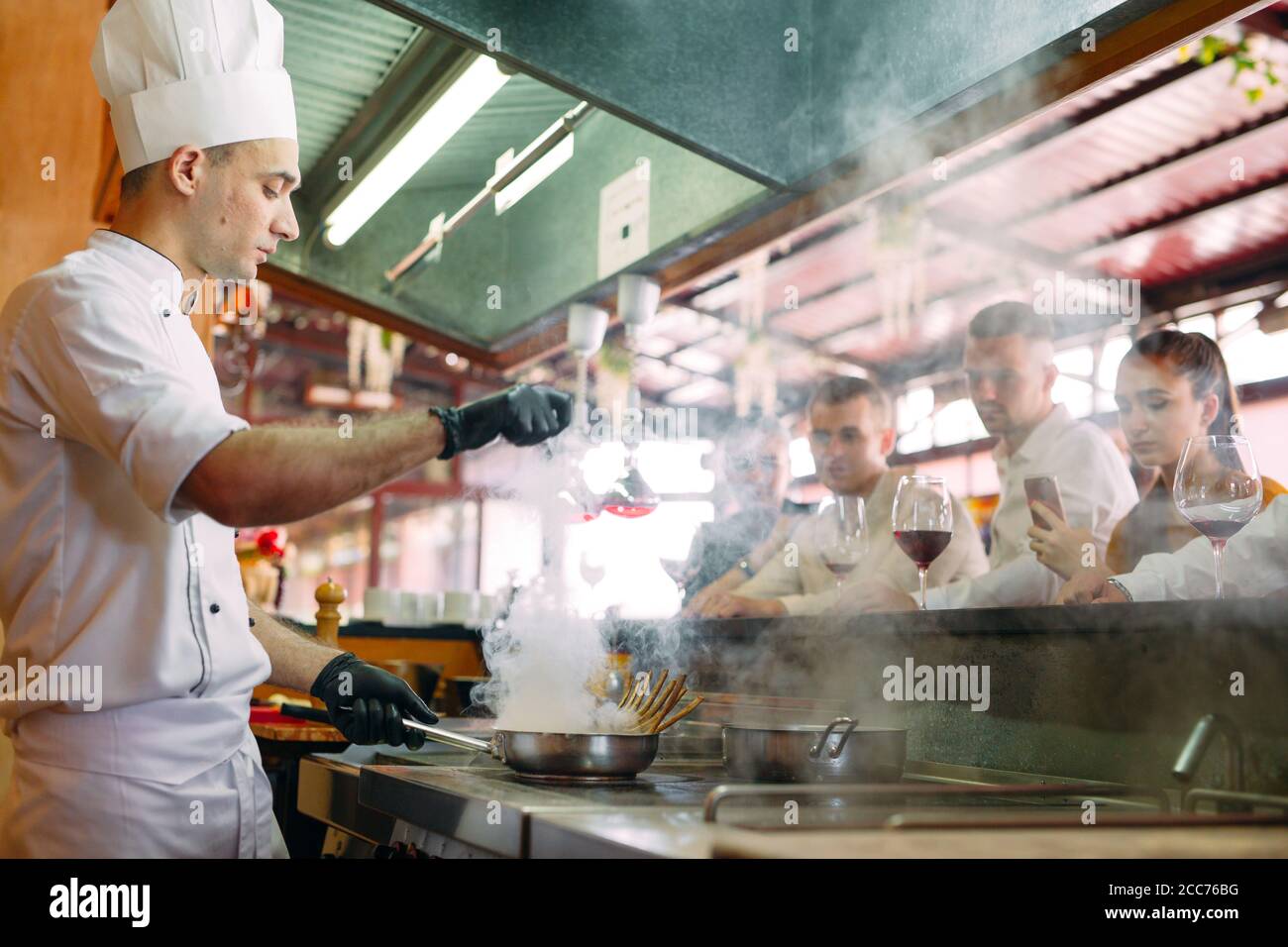 The chef prepares food in front of the visitors in the restaurant Stock ...