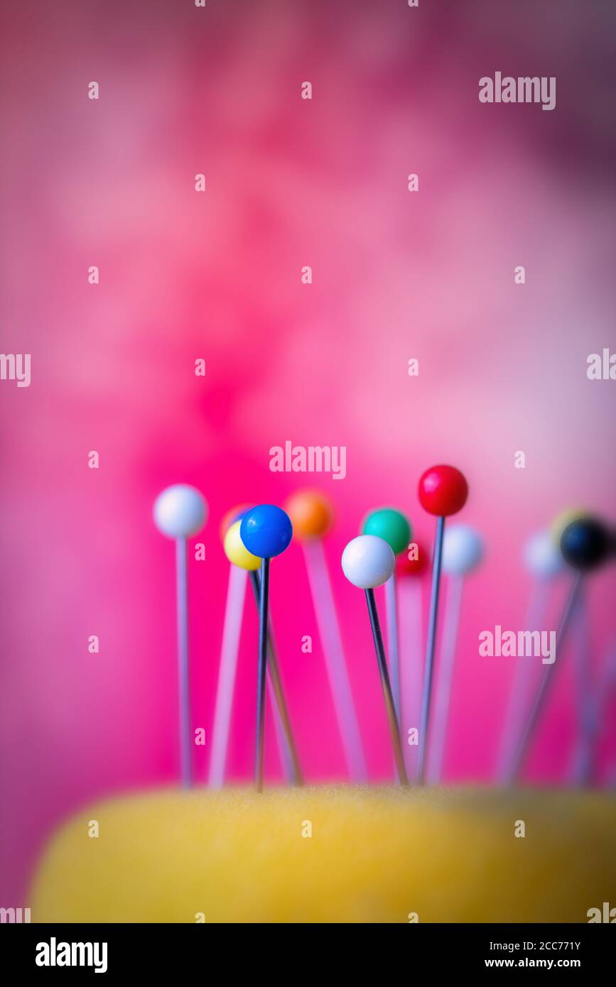 Pin cushion with multi coloured pins and a pink background Stock Photo ...