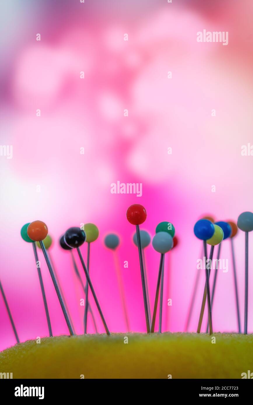 Pin cushion with multi coloured pins and a pink background Stock Photo ...