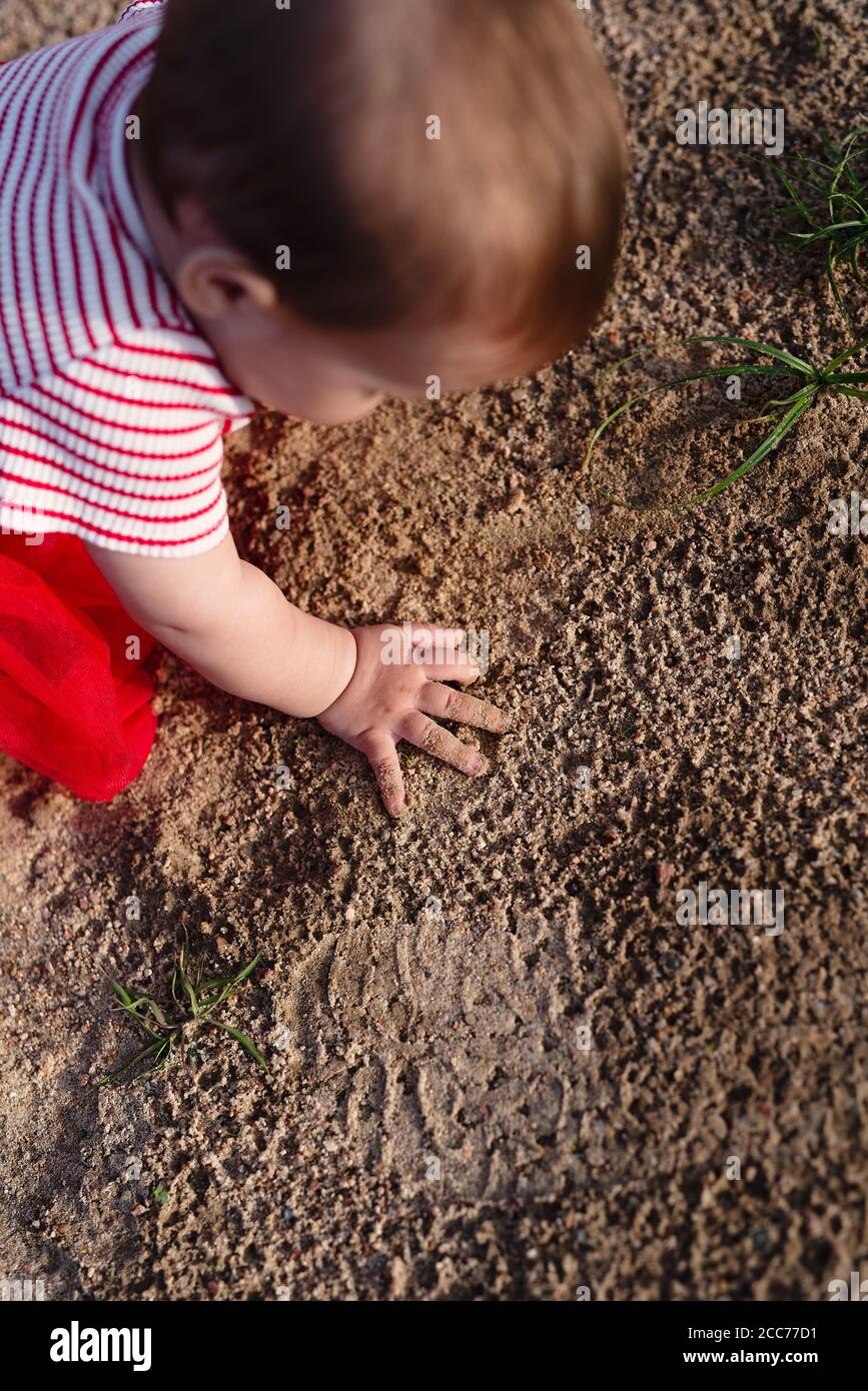 little girl touching sand with hand, top view Stock Photo - Alamy