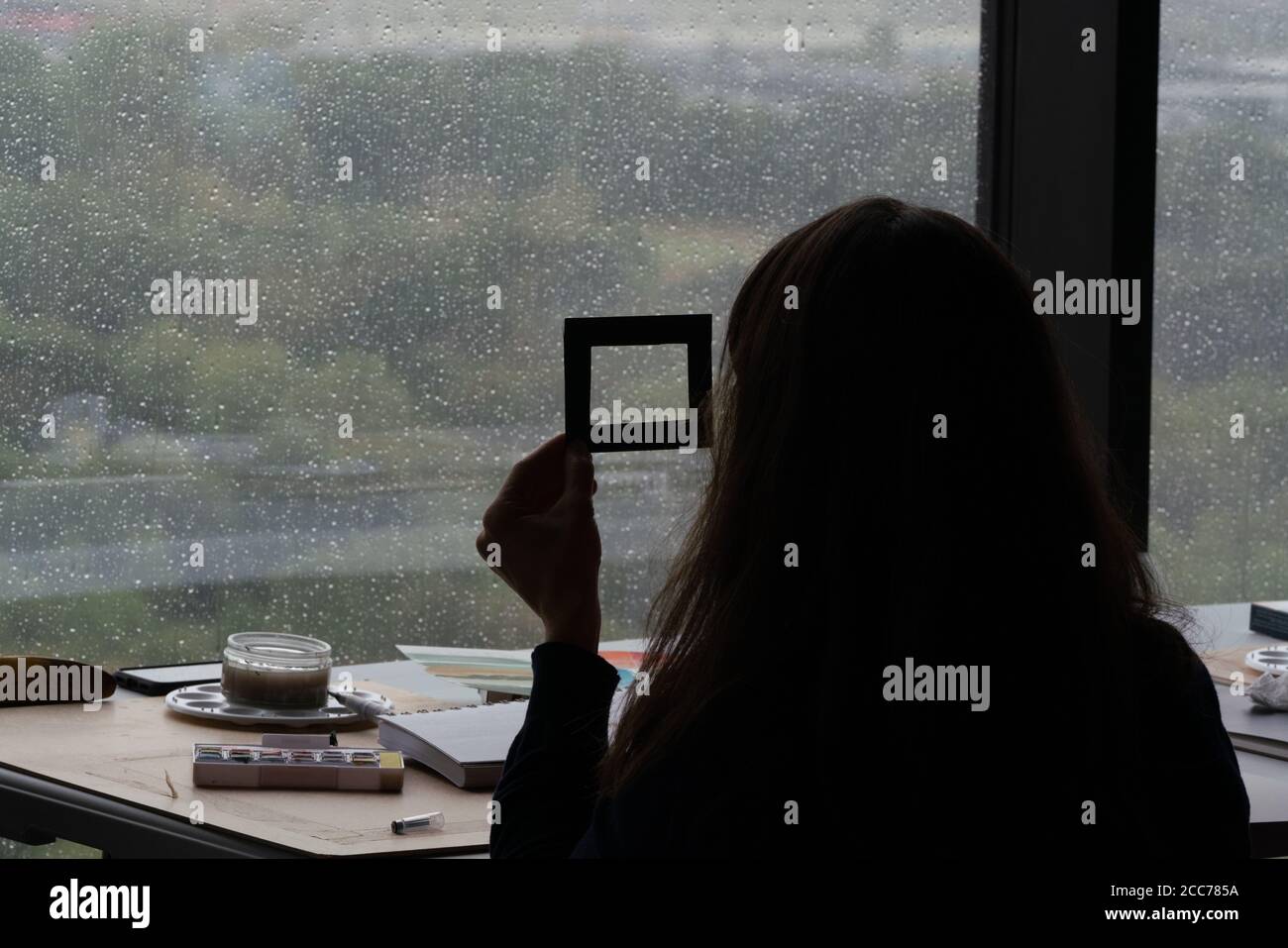 Watercolour painter framing a landscape scene with a cardboard ...
