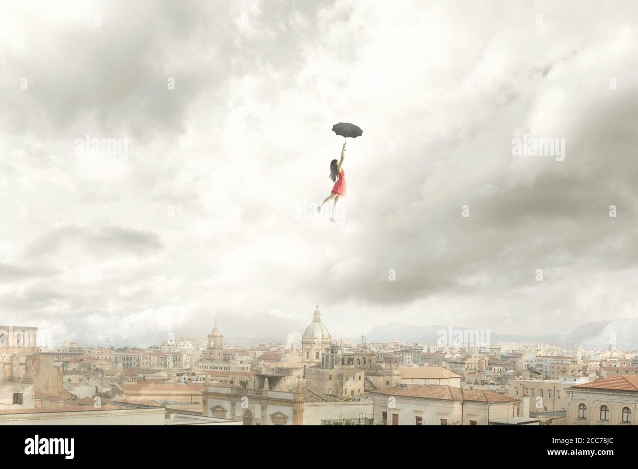 Surreal moment of a woman flying with her umbrella over the city Stock ...