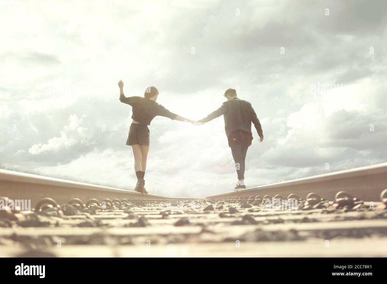 young couple walking hand in abandoned rails in a surreal place Stock ...