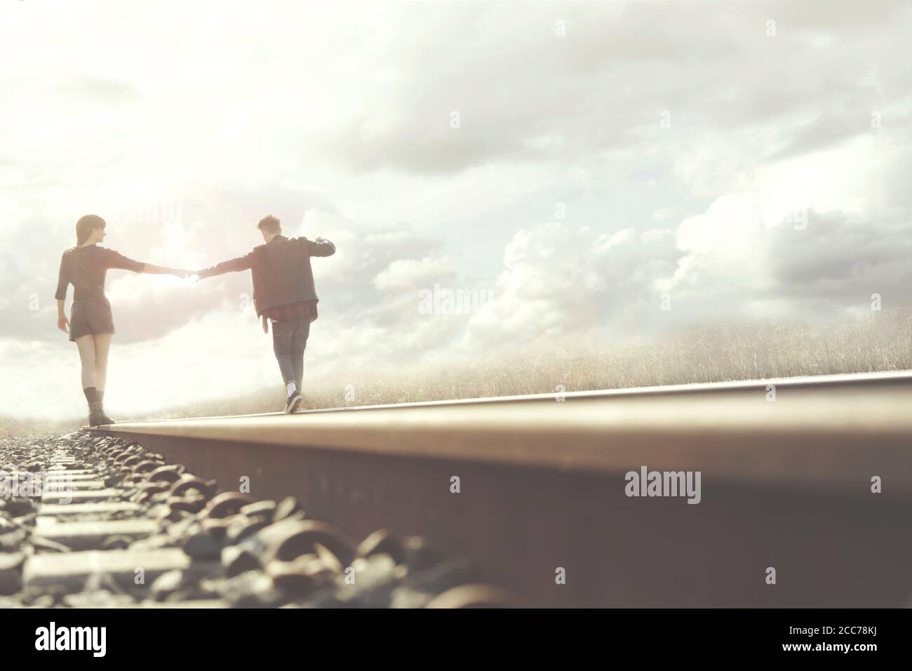 young couple walks hand in hand on rails in a surreal place Stock Photo ...