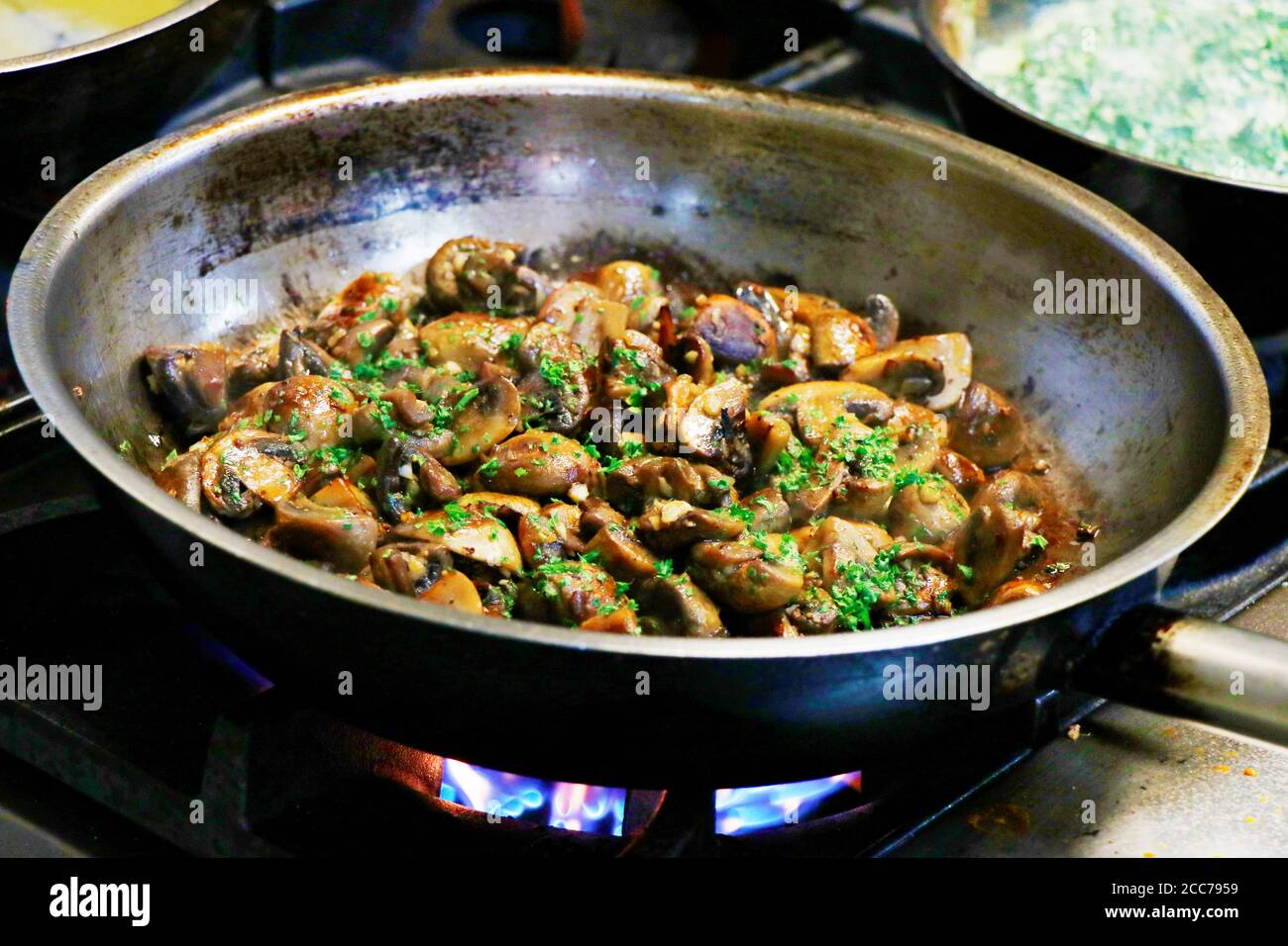 saute button mushrooms in a cooking pan Stock Photo - Alamy
