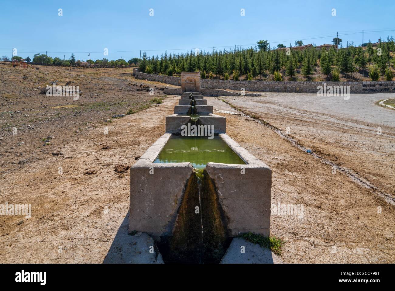 Water flows from the spring to the concrete animal troughs lined up one ...