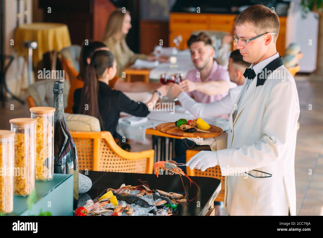 The waiter shifts the seafood on a tray in the restaurant Stock Photo ...