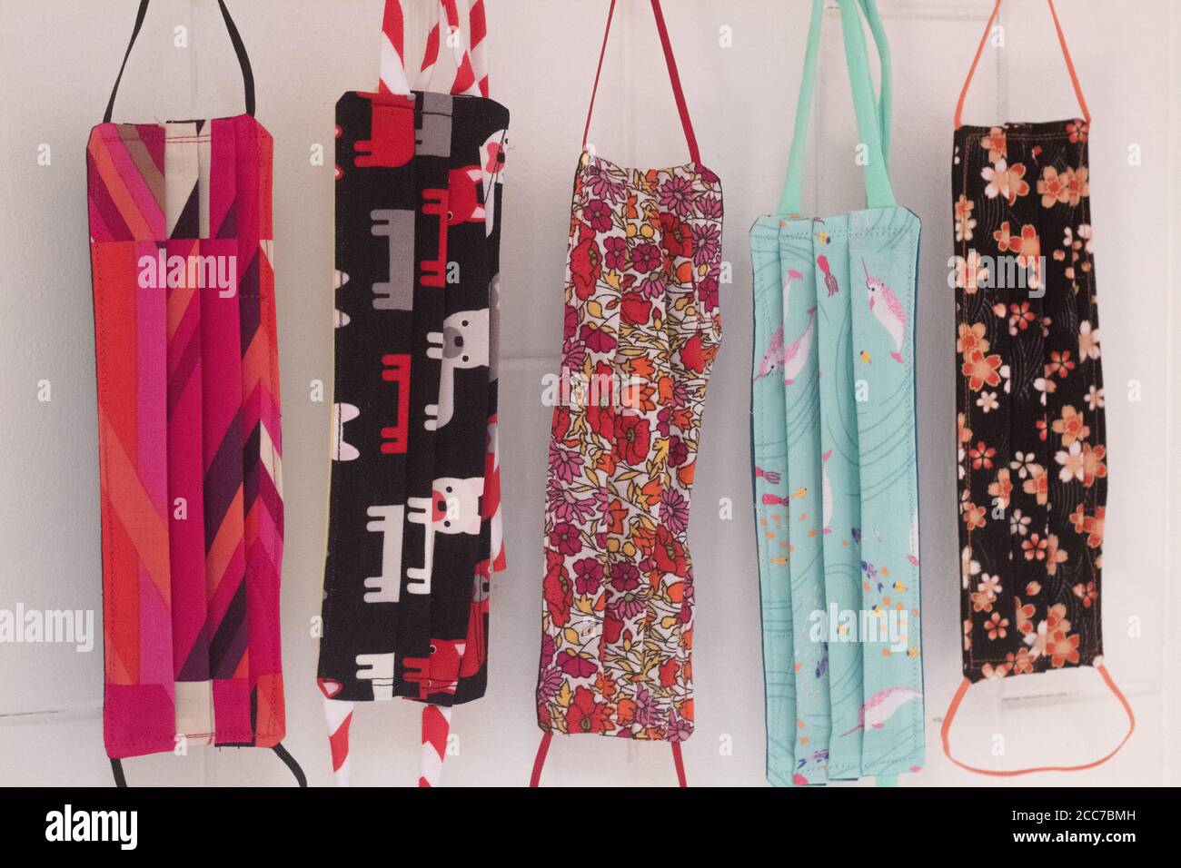 Group of Five Patterned Cute Masks hanging on hooks Stock Photo - Alamy