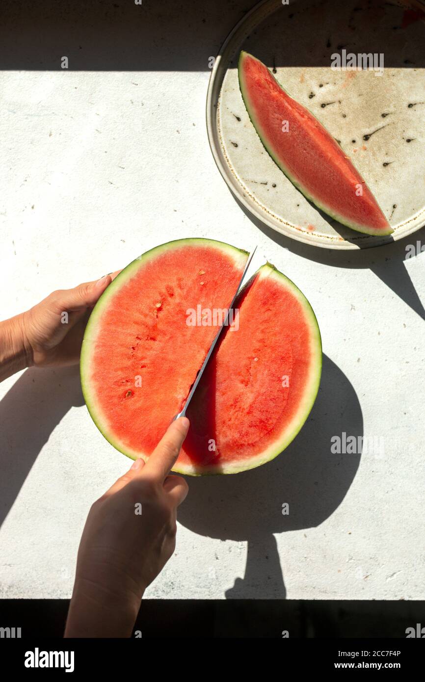 Hands slicing a watermelon Stock Photo - Alamy