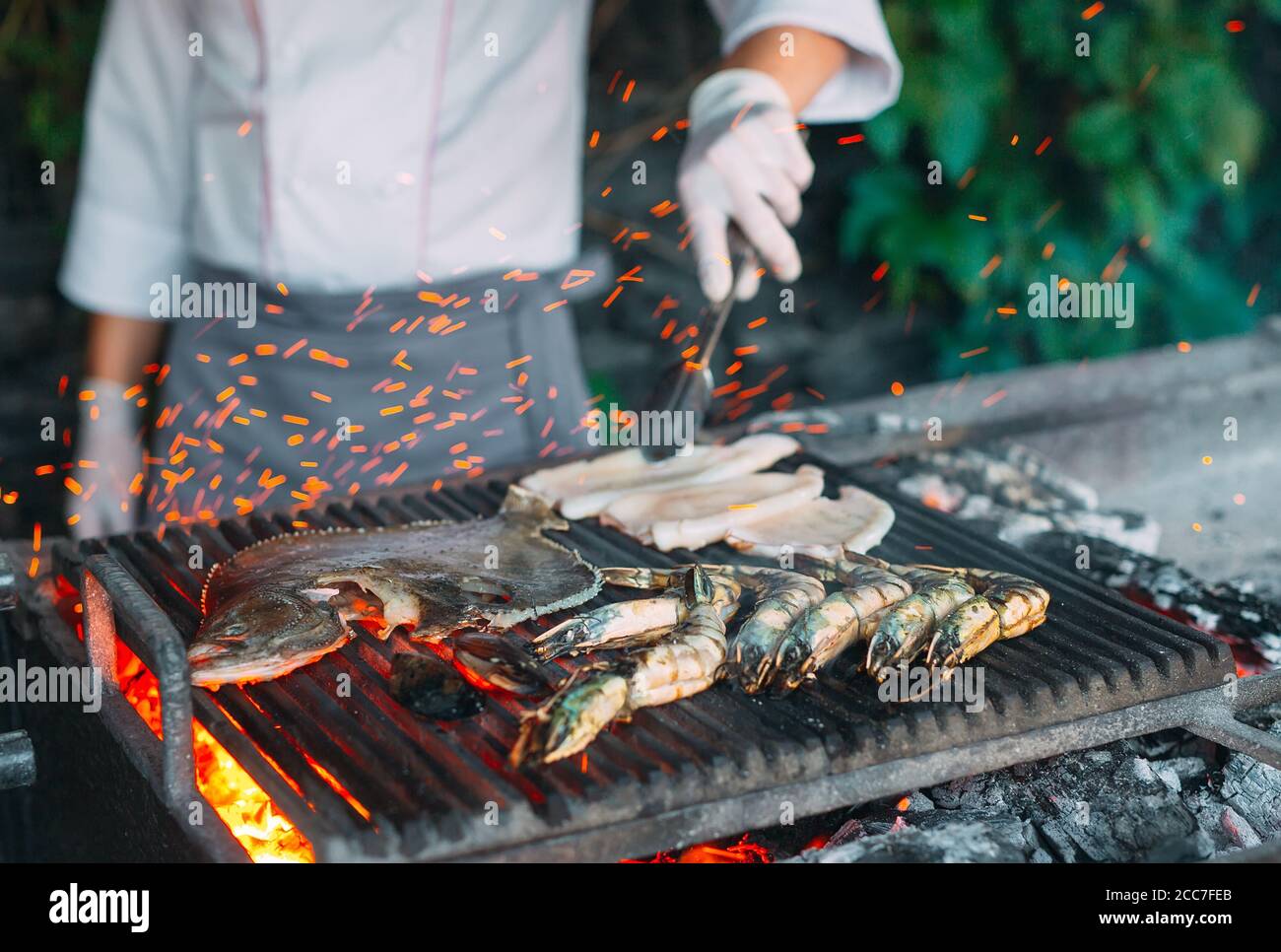 Seafood on the grill. Mussels, shrimp, squid and fish are cooked on ...