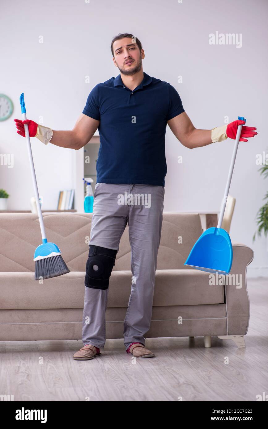 Young leg injured contractor cleaning house Stock Photo - Alamy