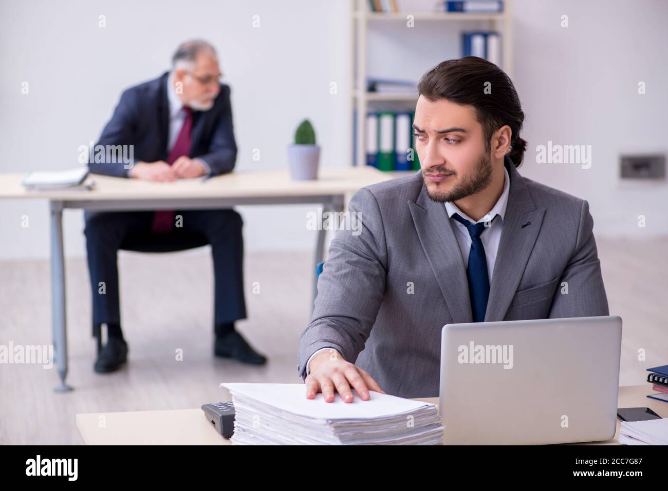 Old boss and his assistant working in the office Stock Photo - Alamy