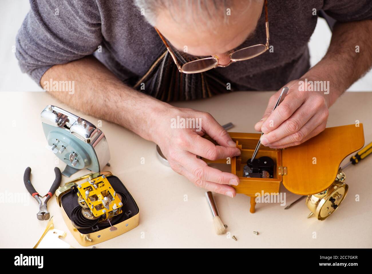 Old watchmaker working in the workshop Stock Photo - Alamy
