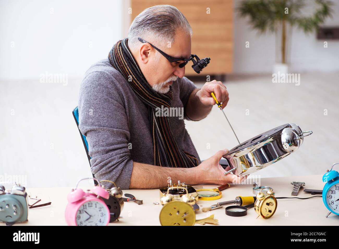 Old watchmaker working in the workshop Stock Photo - Alamy